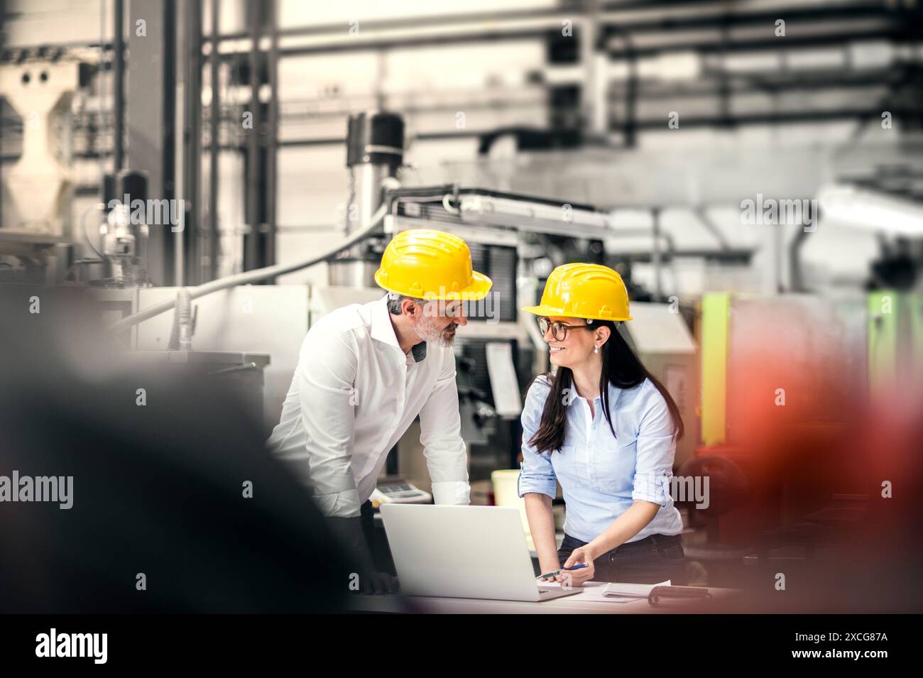 Two project managers standing in modern industrial factory ...