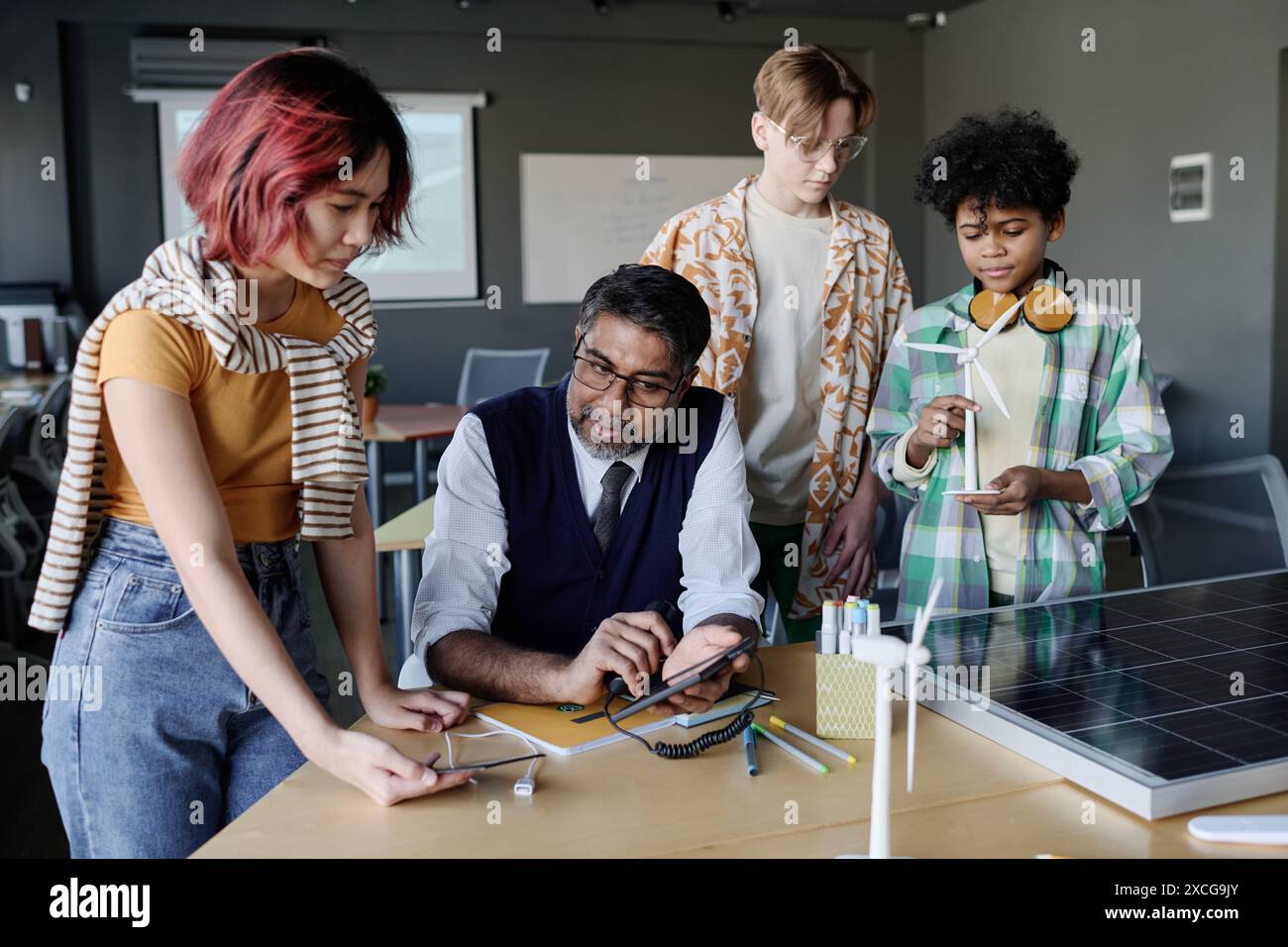 Group of ethnically diverse students learning about renewable energy ...