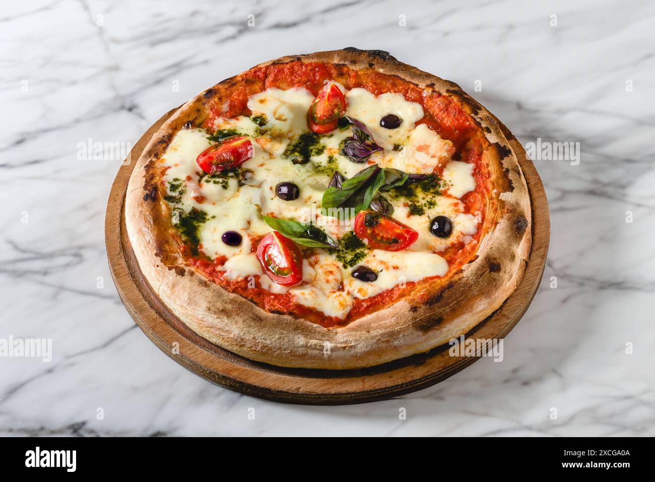 Neapolitan pizza with tomatoes, mozzarella, basil and olives on marble ...