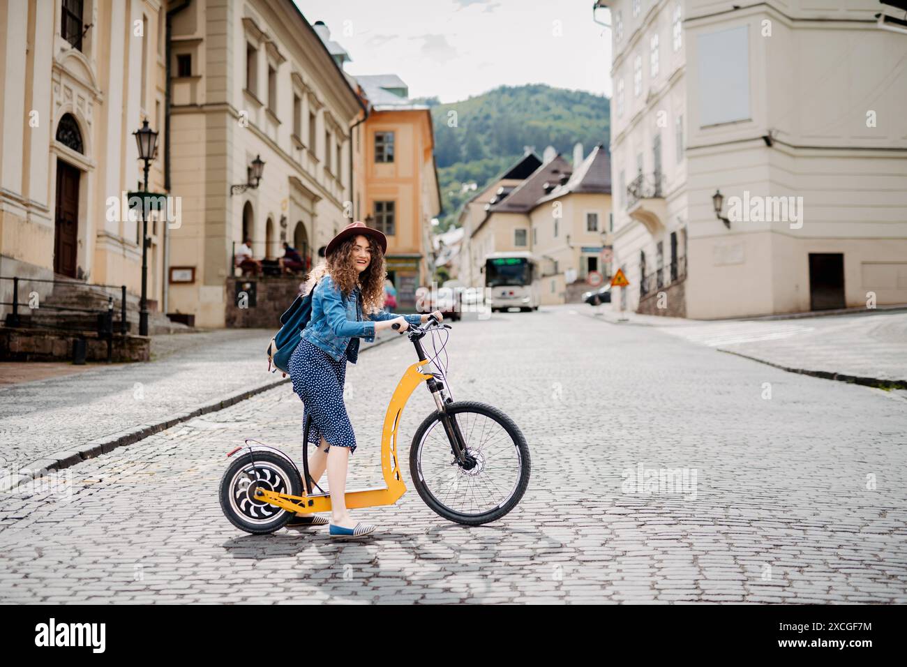 Female traveller on electric scooter in small city, sightseeing. Young ...