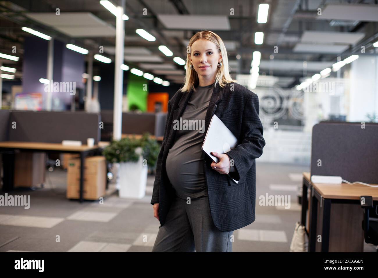 Portrait of a beautiful pregnant woman working in an office with a ...