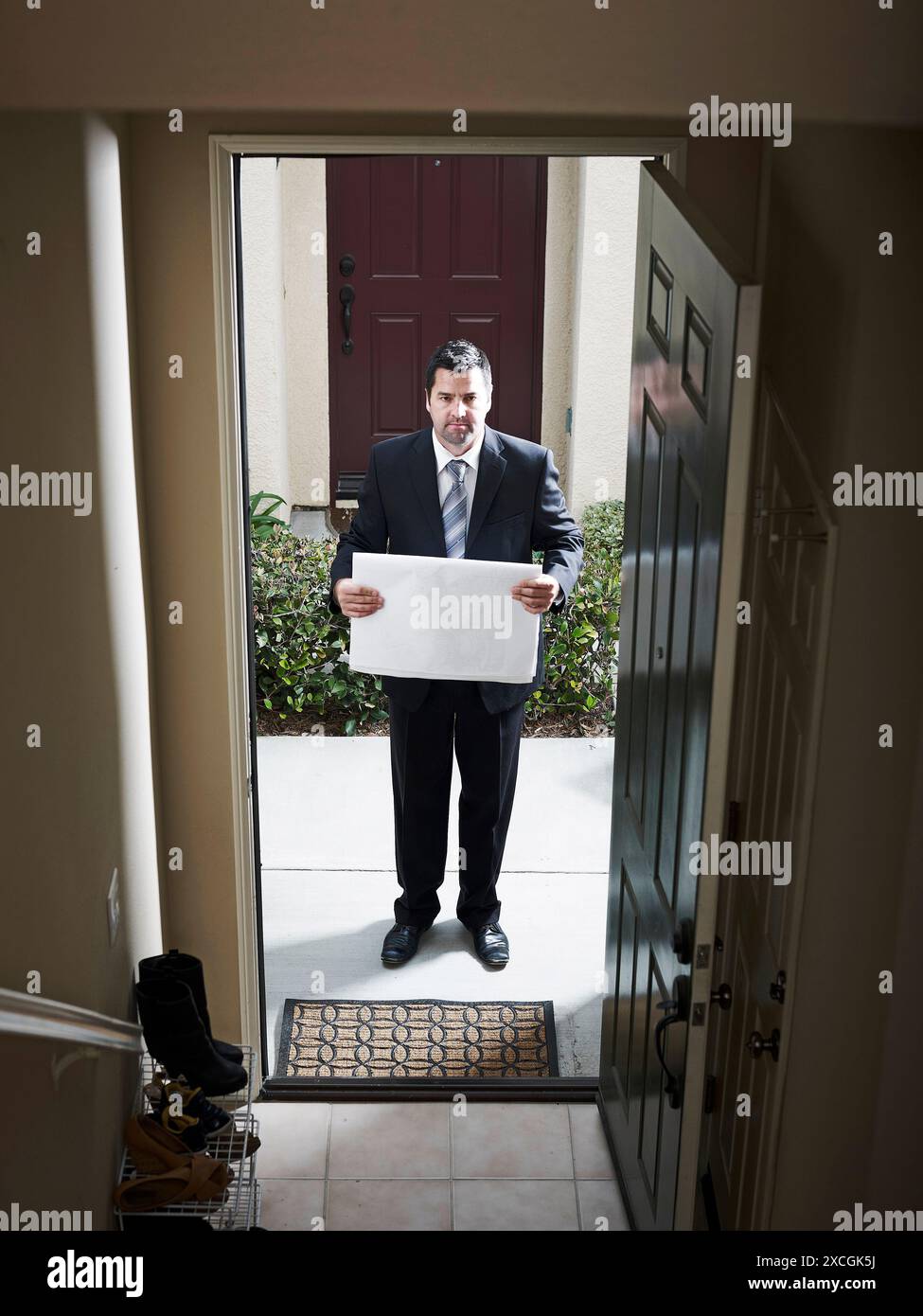 Business man at the door holding a white sign Stock Photo - Alamy
