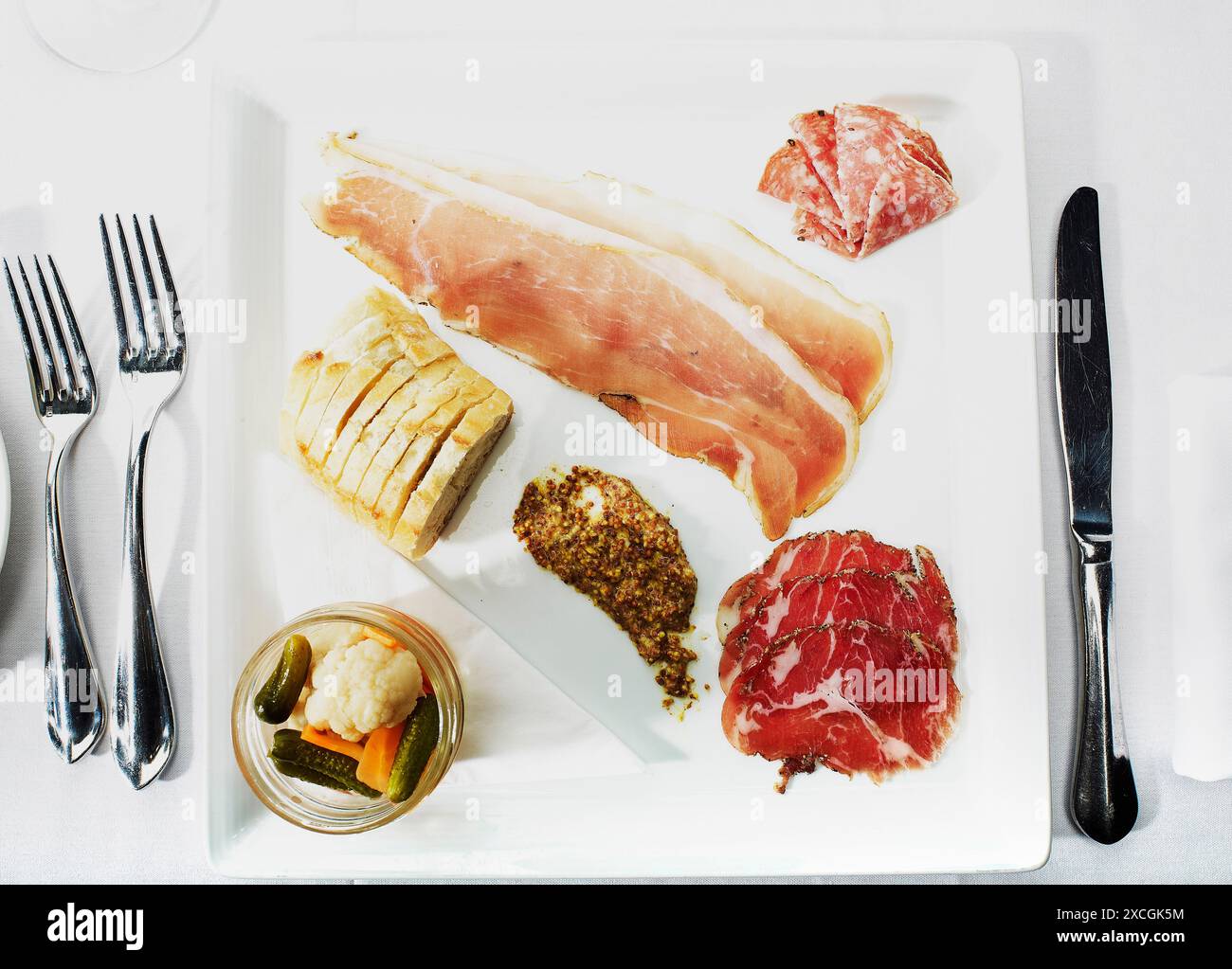 Breakfast dish with several types of ham, vegetables and bread Stock ...