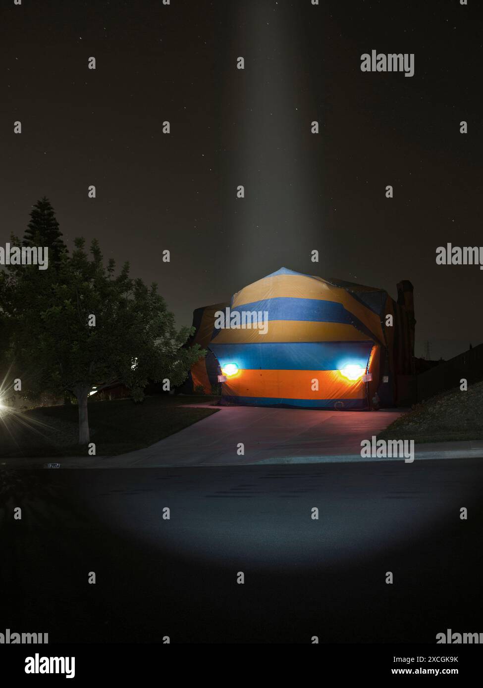 A home at night in San Diego is tented as it is fumigated inside to ...