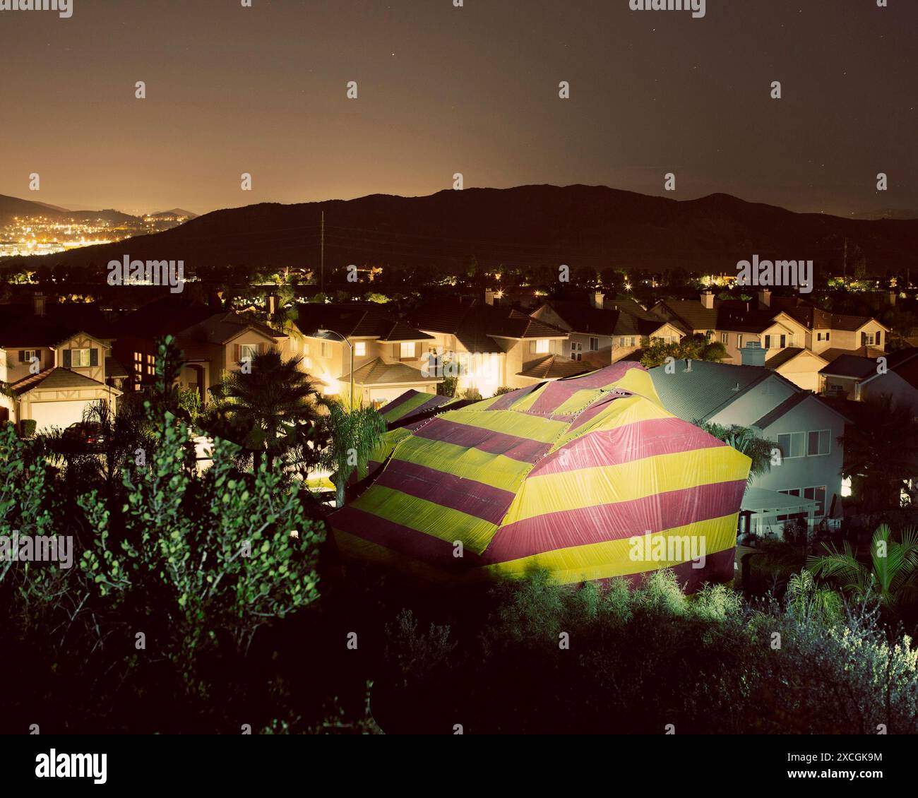 A home at night in San Diego is tented as it is fumigated inside to ...