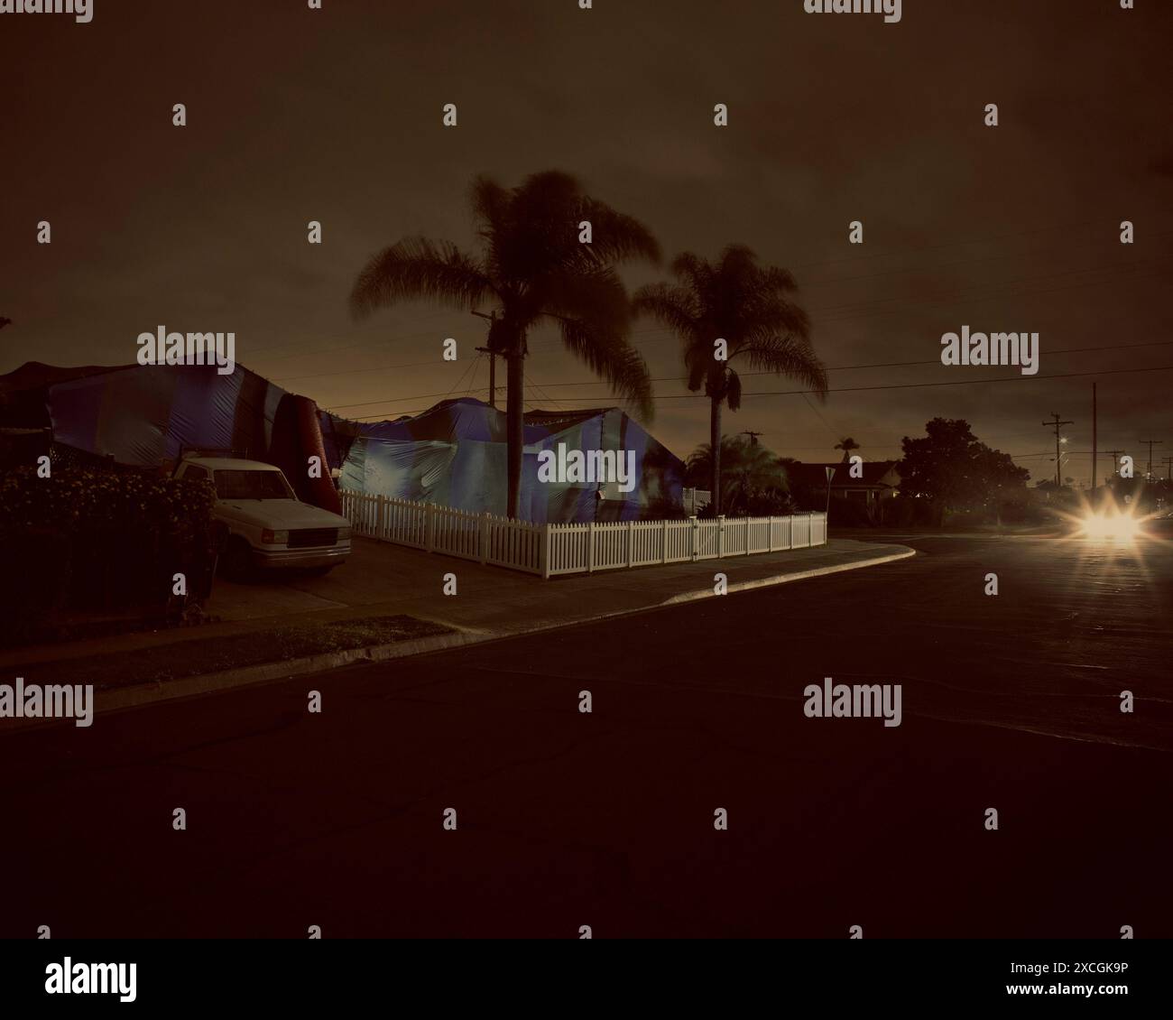 A home at night in San Diego is tented as it is fumigated inside to ...