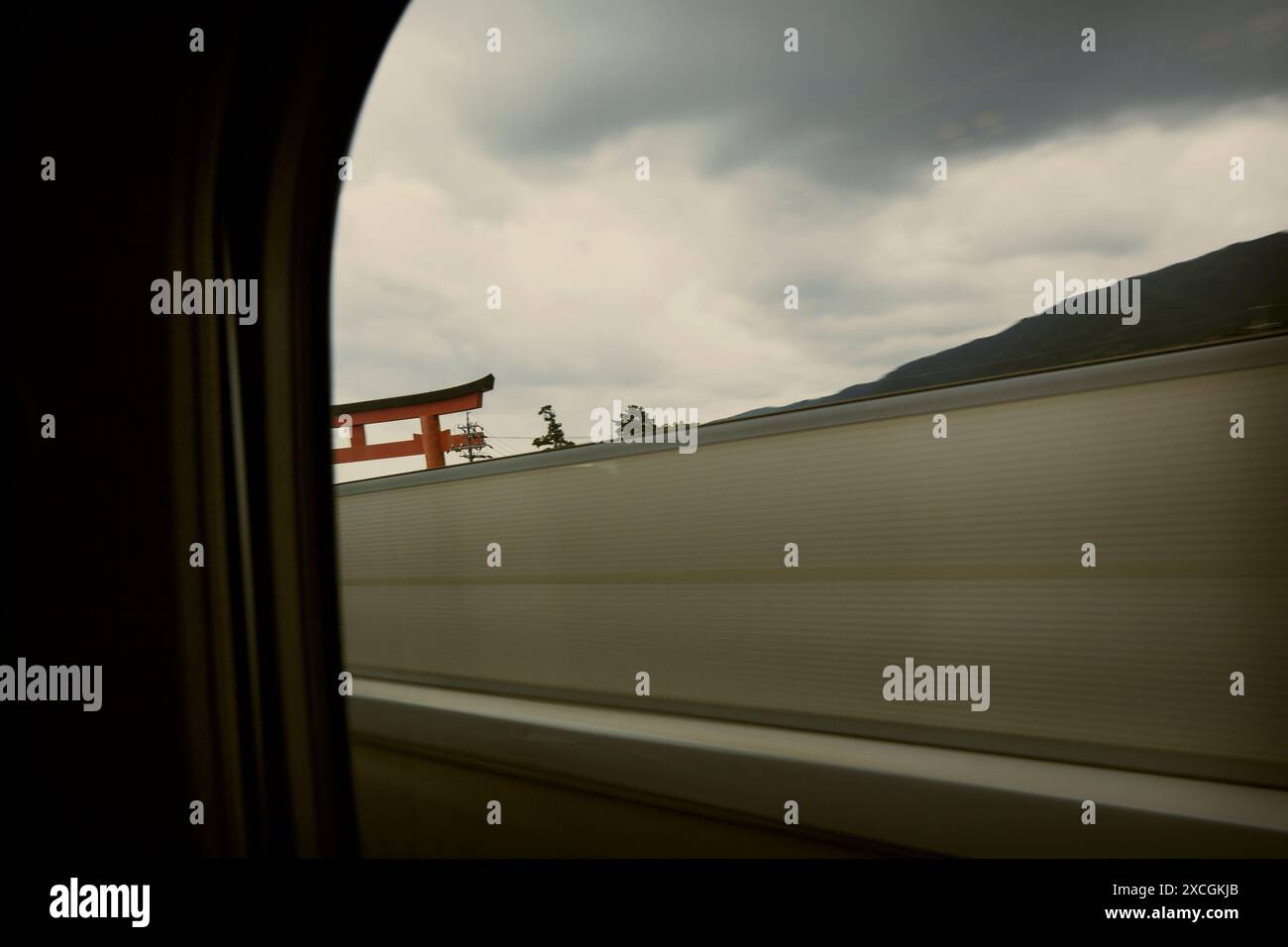 Blurry wave of Japan bullet train and an urban view of a small hill ...