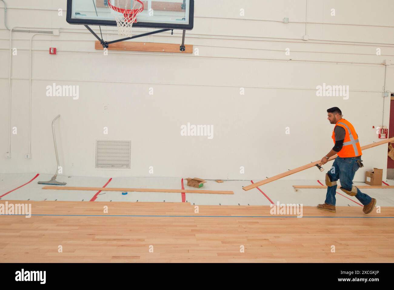 A worker lays maple wood flooring in a basketball court Stock Photo - Alamy