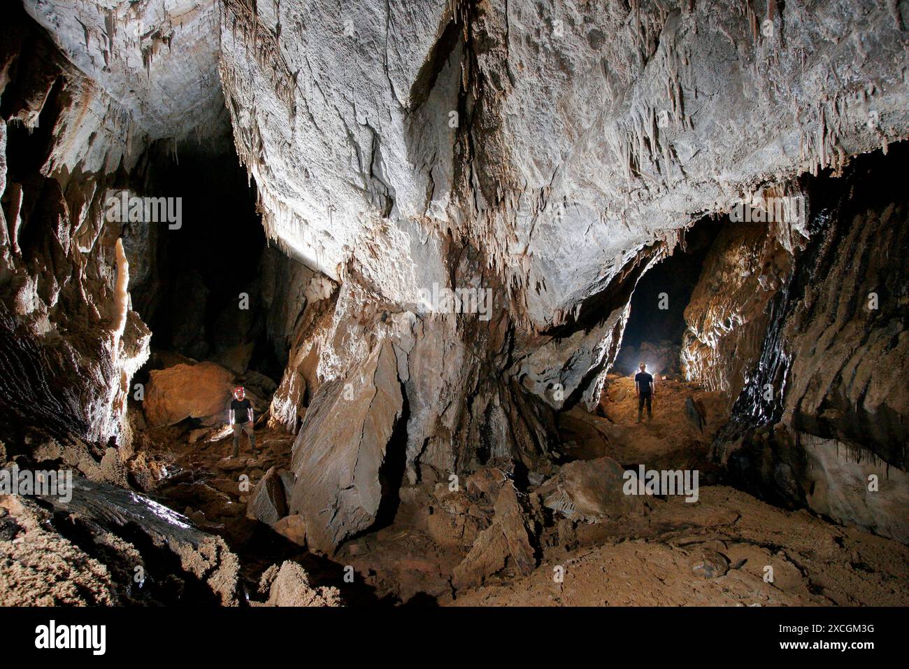 Two cave explorers give scale to a mirror image passage in a cave in ...