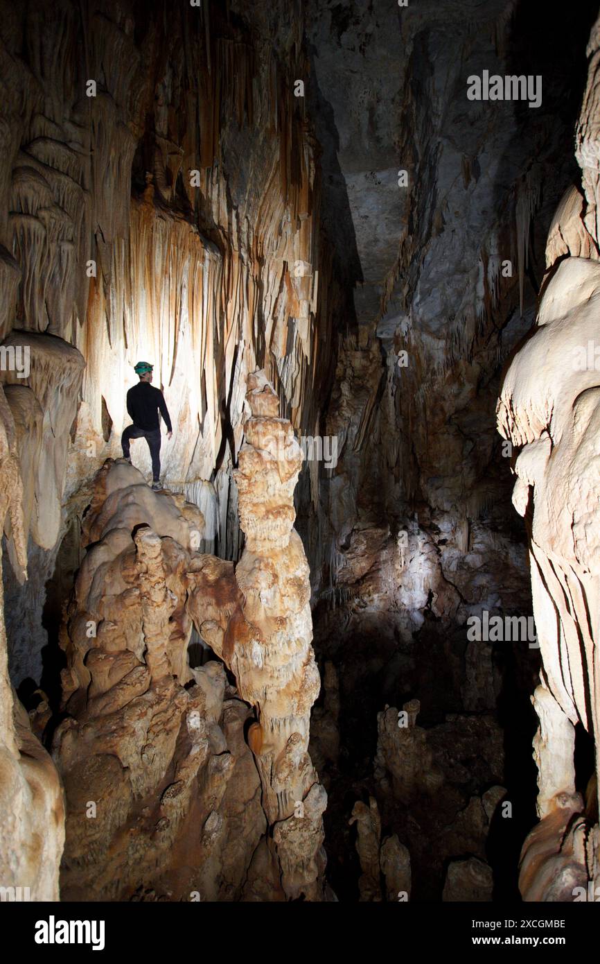 Two cave explorers add scale to a large room underground in a cave in ...