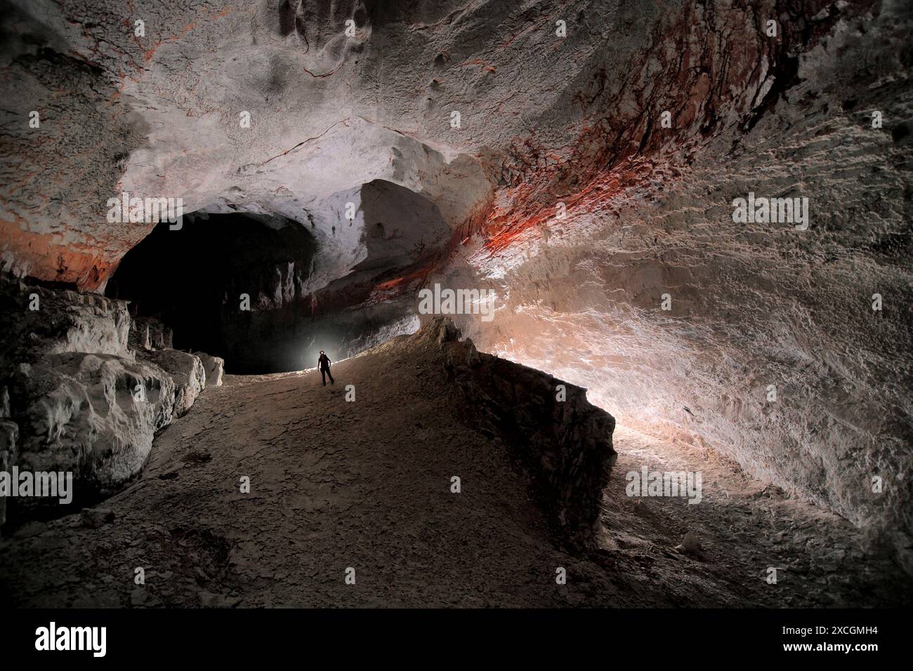 A lonesome British cave explorer wanders down a snady ramp in this ...