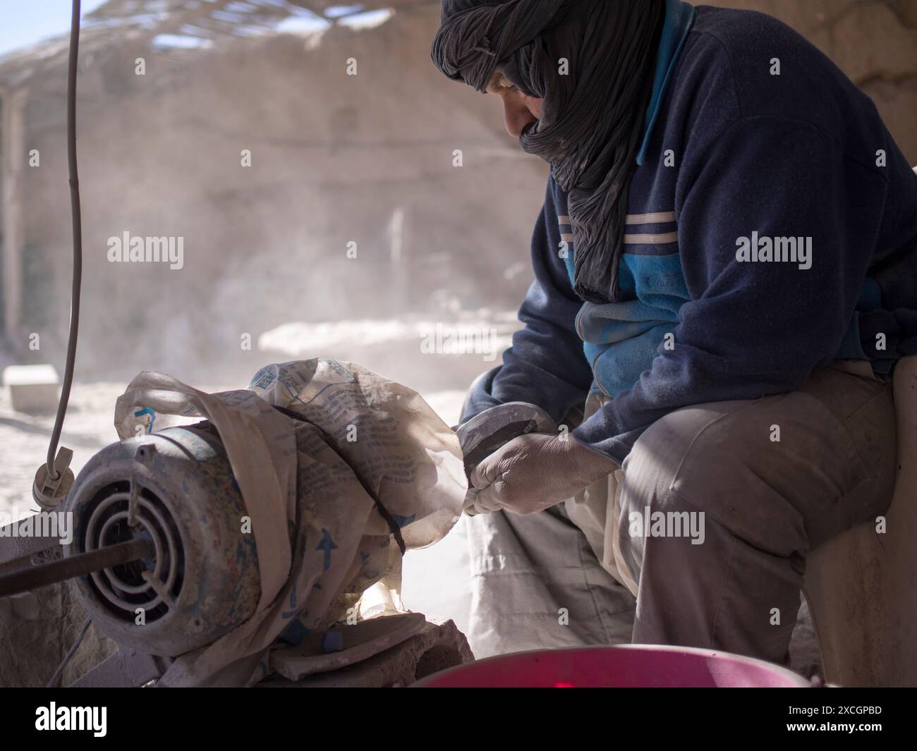 Man grinding fossilized creatures, Morocco Stock Photo - Alamy
