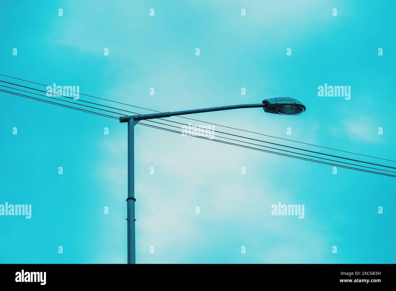 Street light lamp post and electricity wires on overcast winter day ...