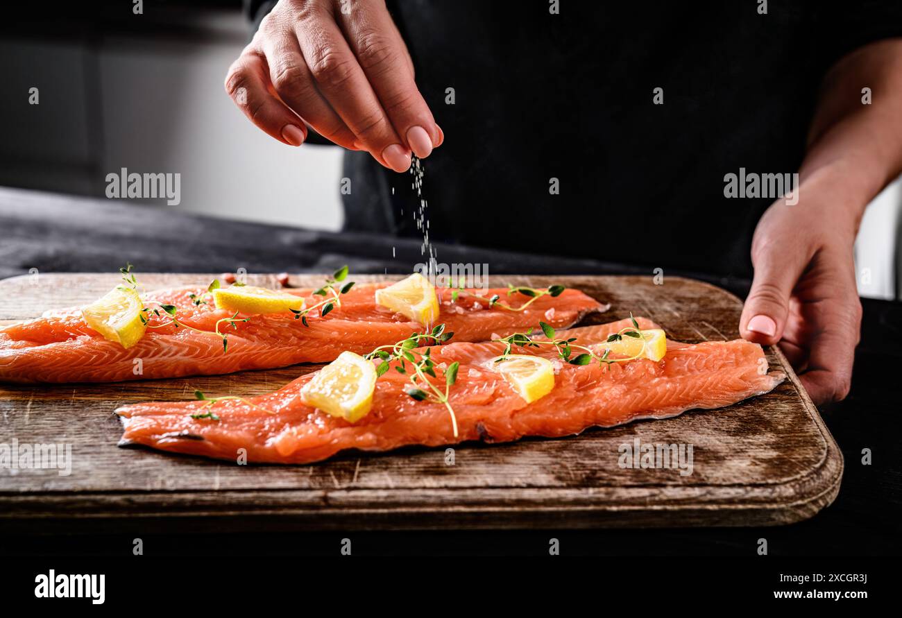 Chief Salting With A Pinch Of Salt Raw Red Trout Fish For Cooking At ...