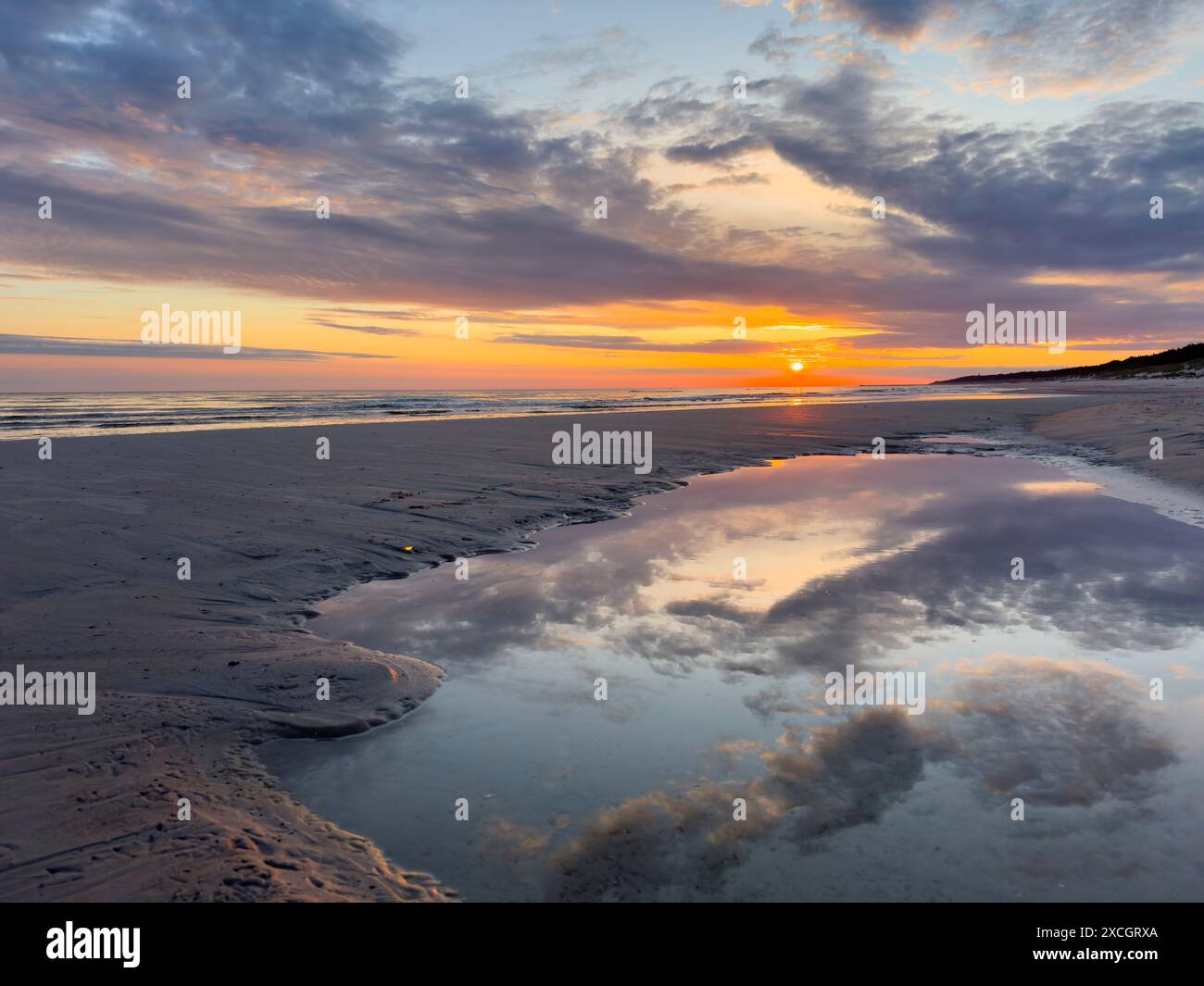sunrise in the morning over the baltic sea with wave on the sand beach ...