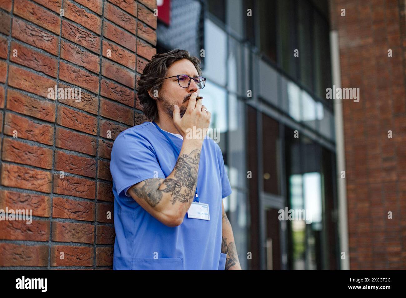 Healthcare worker taking a break, smoking a cigarette outdoors, in ...