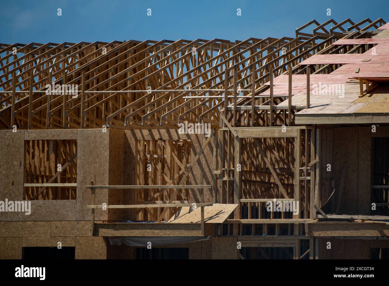 Framing and roofing. Timber frame of a house against a blue sky. The ...