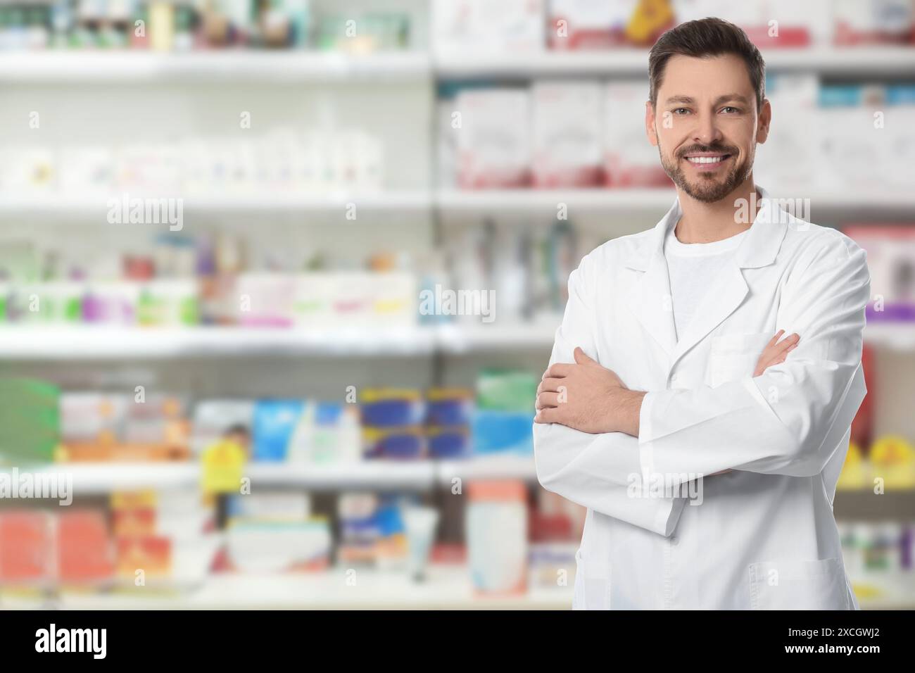 Positive pharmacist in uniform at drugstore. Space for text Stock Photo ...