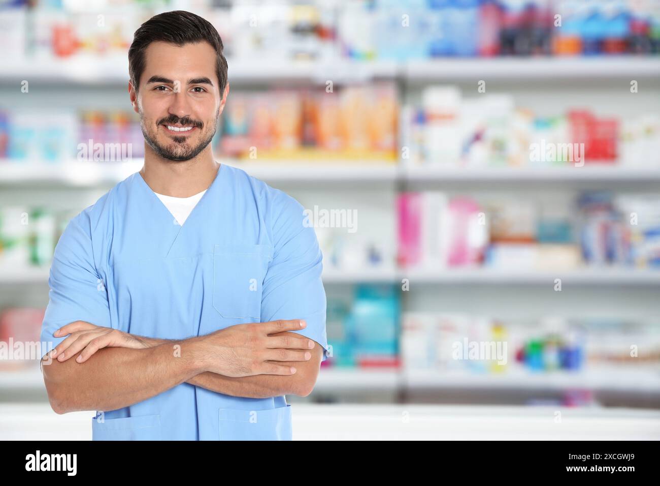 Positive pharmacist in uniform at drugstore. Space for text Stock Photo ...