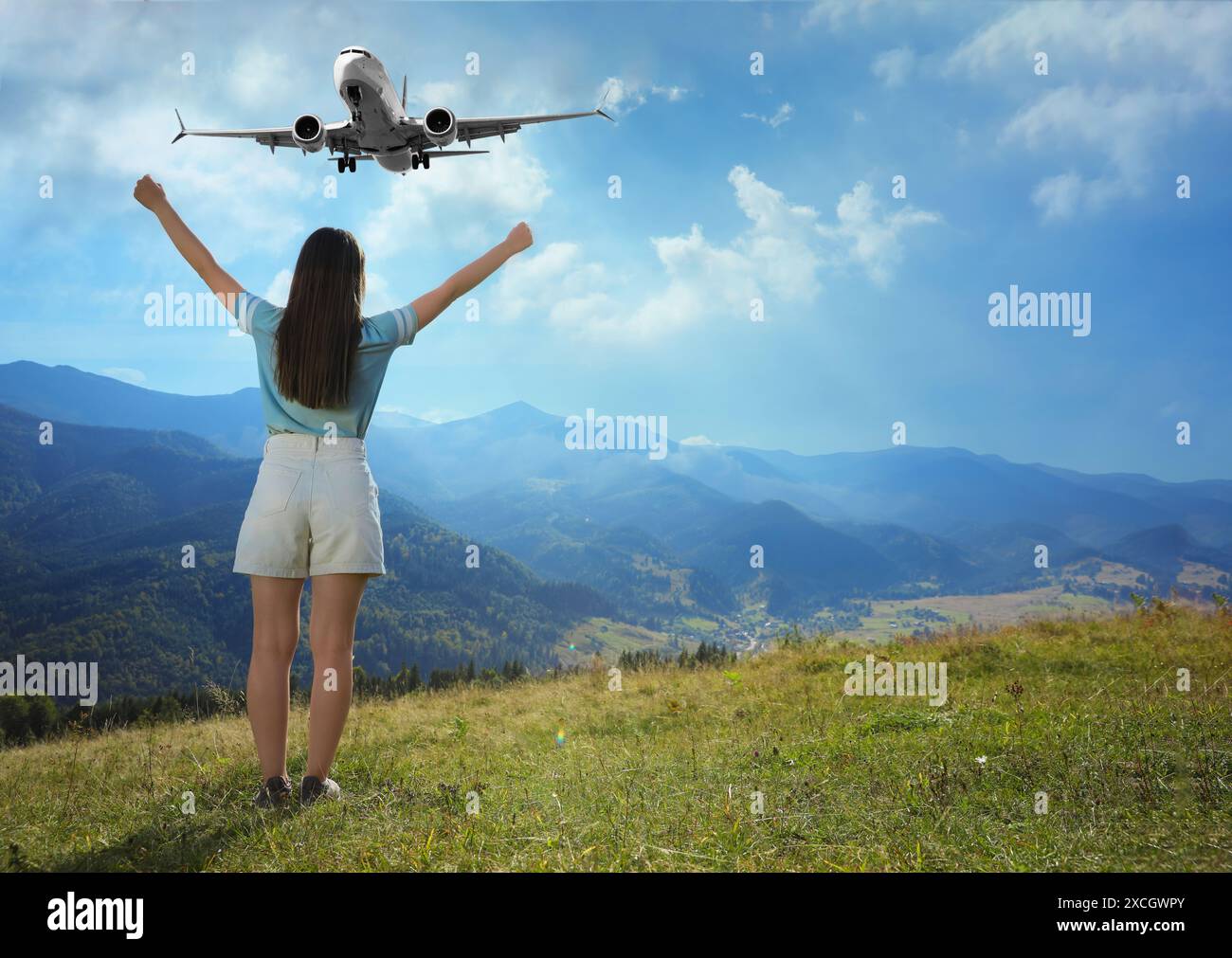 Woman looking at airplane flying in sky over mountains, back view Stock ...