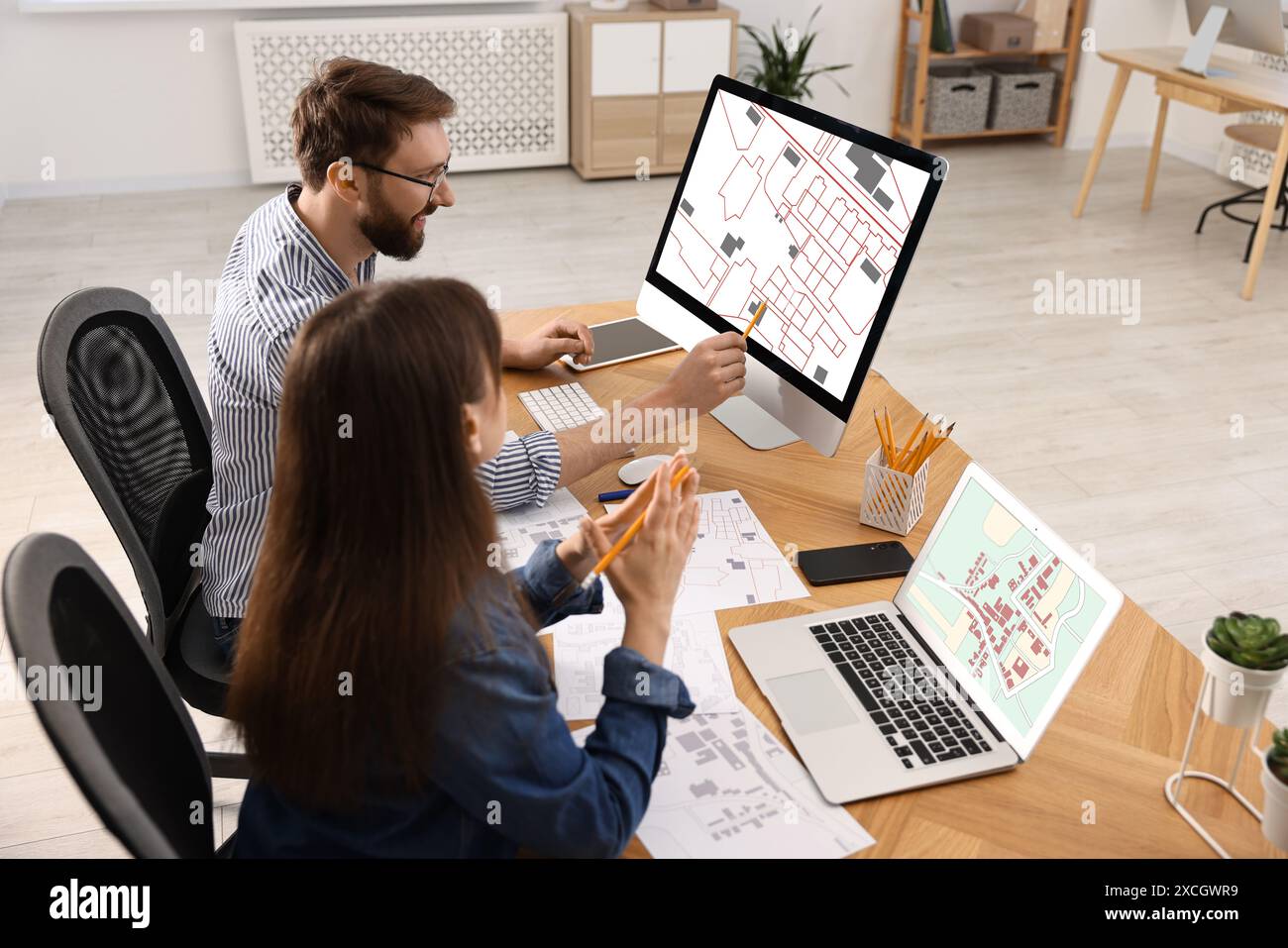 Cartographers working with cadastral maps at table in office Stock ...