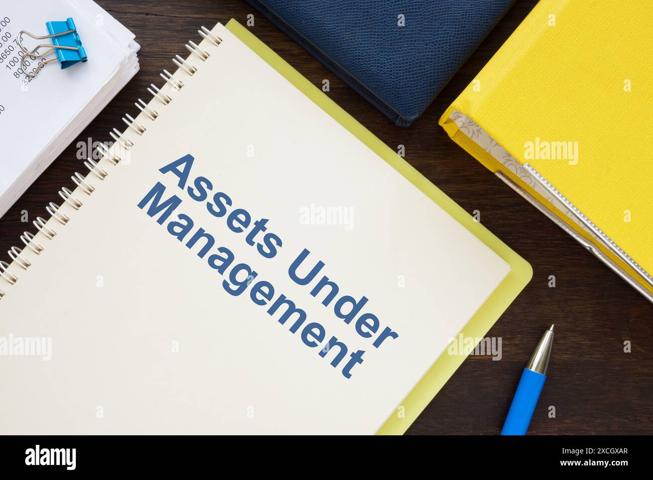 Papers about assets under management and notebook Stock Photo - Alamy