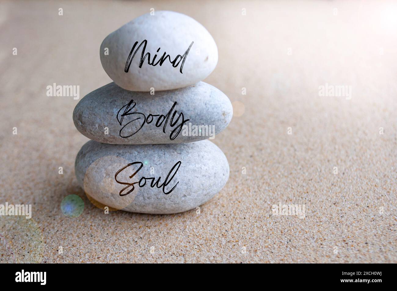Mind, body and soul text on zen stones with bright shining light ...