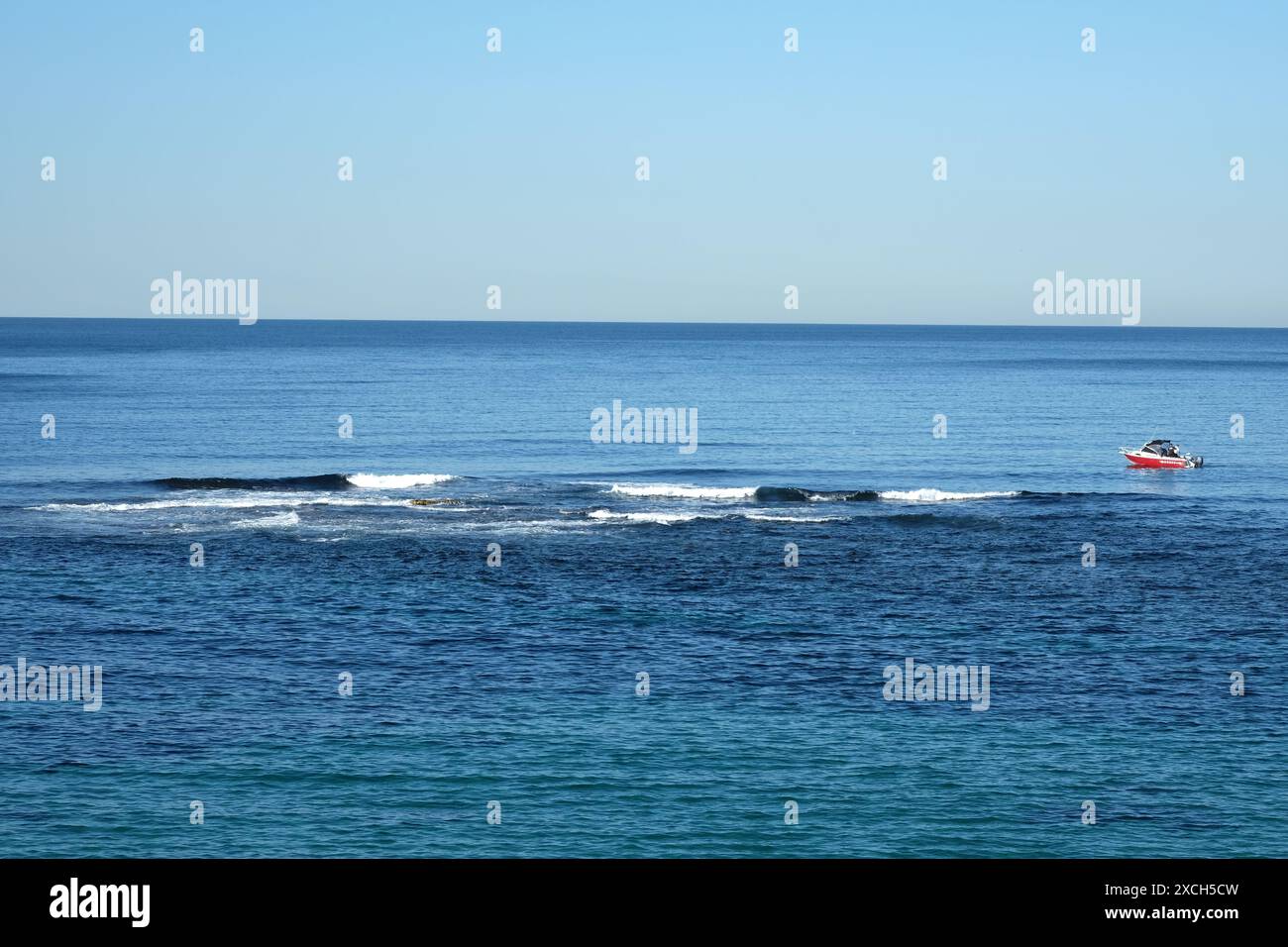 Recreational fishing in a beautiful aqua blue sea under a light blue ...