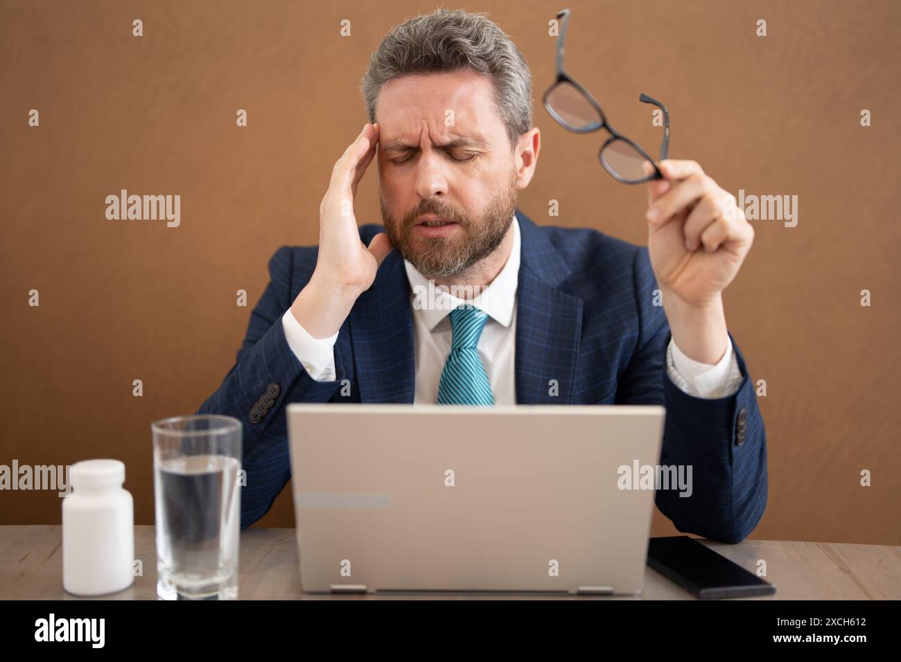 Business man suffering from headache after computer work, exhausted ...