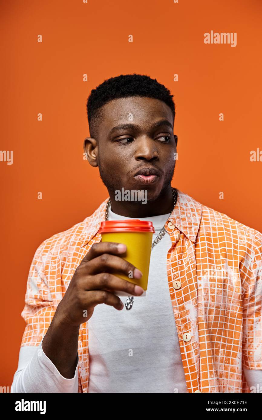 Handsome man in orange shirt enjoying coffee Stock Photo - Alamy