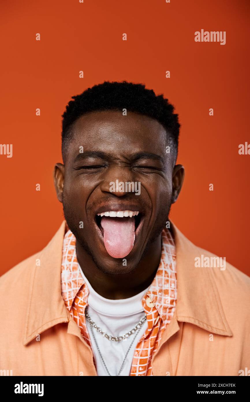 Handsome African American man playfully sticks out his tongue against a ...