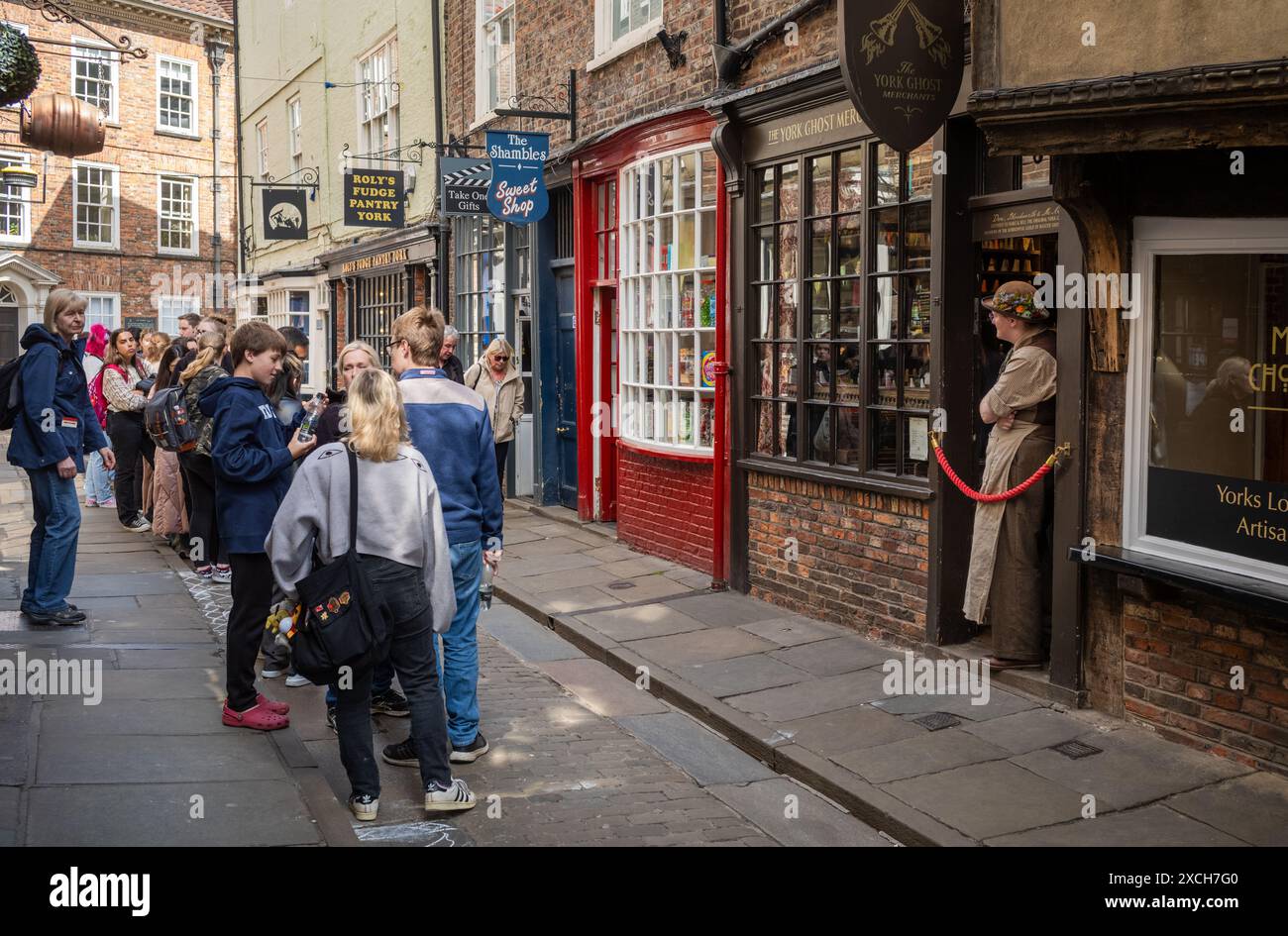 A woman in traditional costume watches tourists from the doorway of The ...