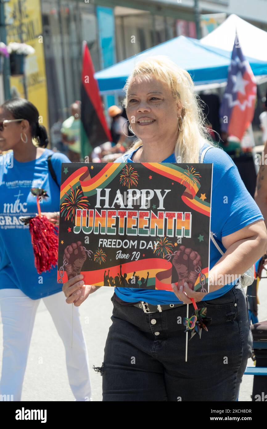 A marcher holding a Happy Juneteenth placard in the 2024 Peekskill ...