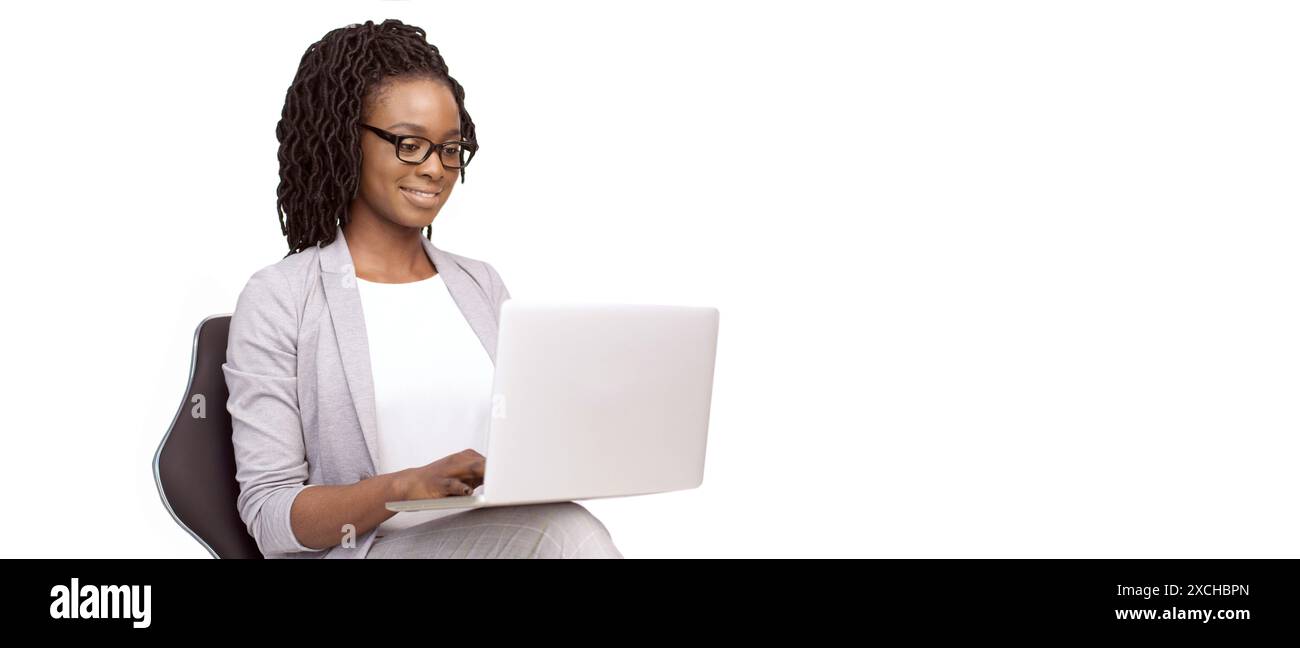 Black businesswoman wearing eyeglasses using laptop on white background ...