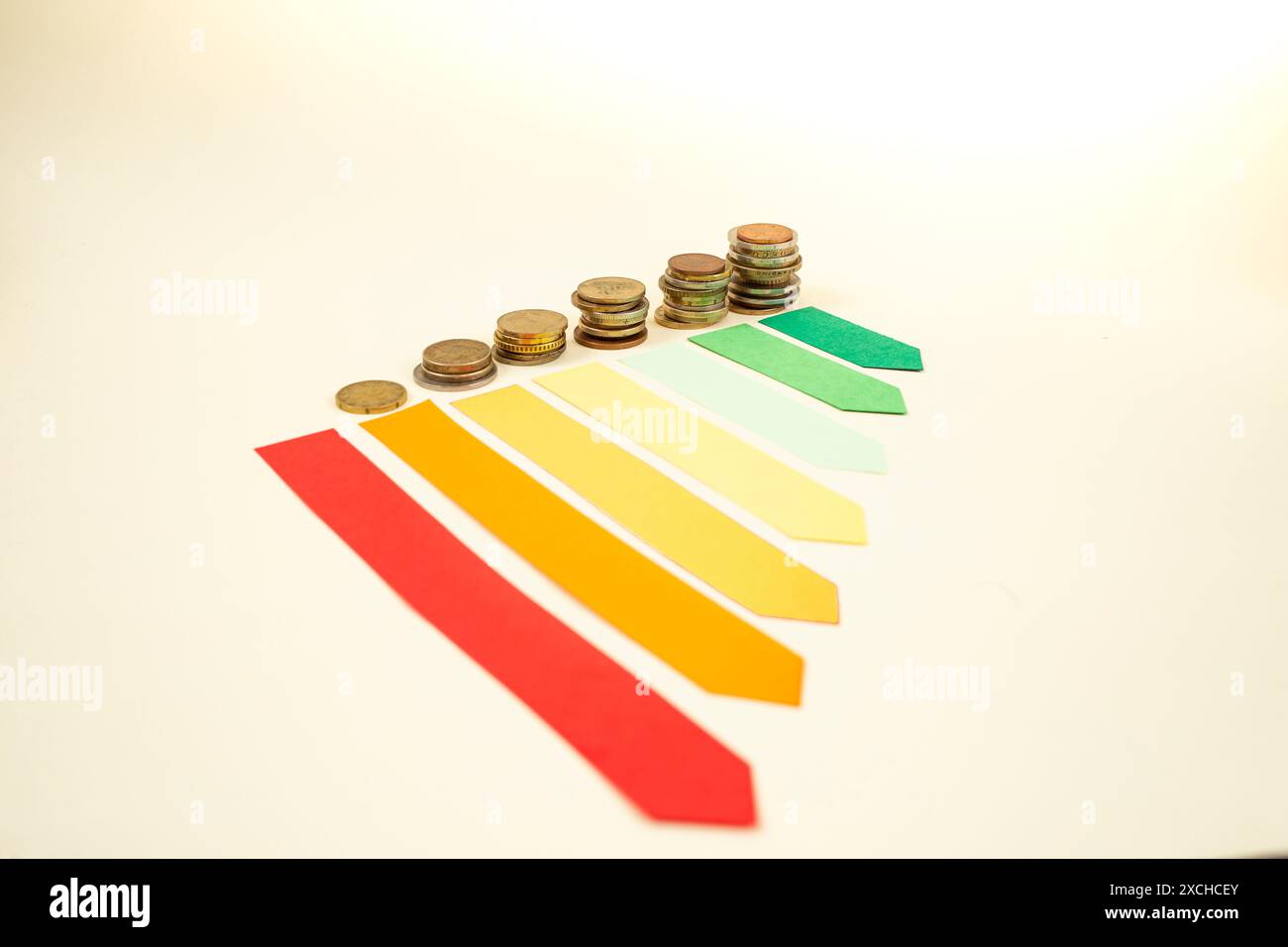 Energy efficiency rating chart and increasing coin stacks on beige ...