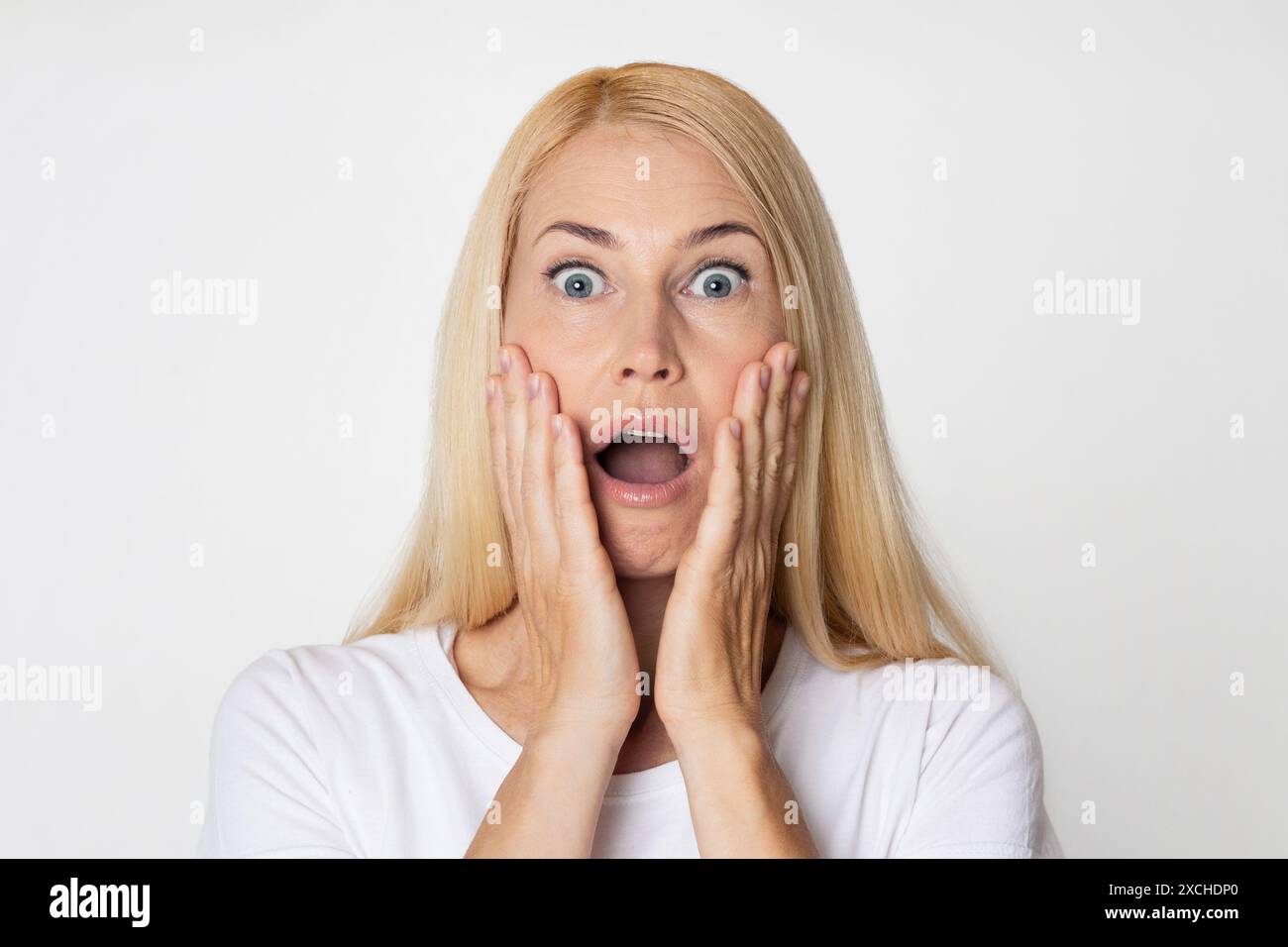 Woman With Blonde Hair Expressing Shock in Front of White Stock Photo ...