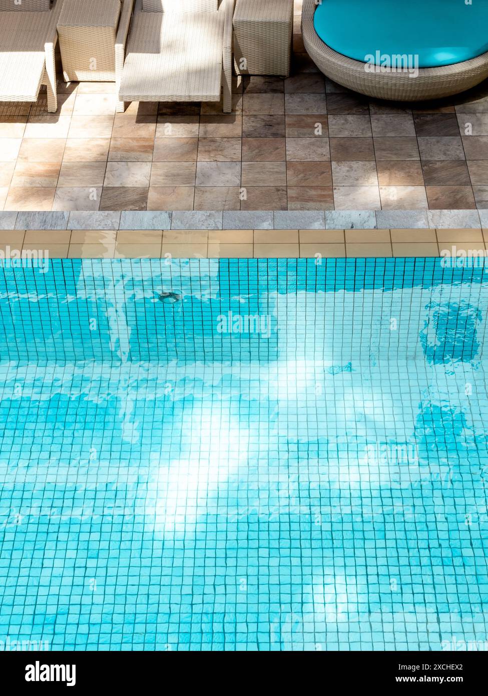 Top view of bright, clean and clear water pool on blue grid mosaic ...