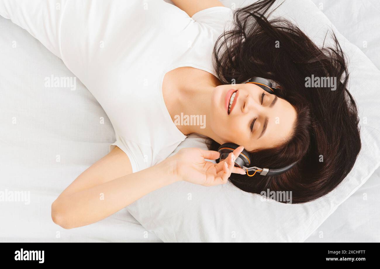 Woman Relaxing on Bed Listening to Music With Headphones Stock Photo ...