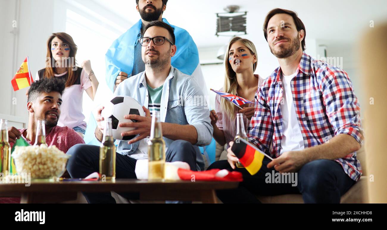 Group of friends having fun at home, watching game and enjoying ...