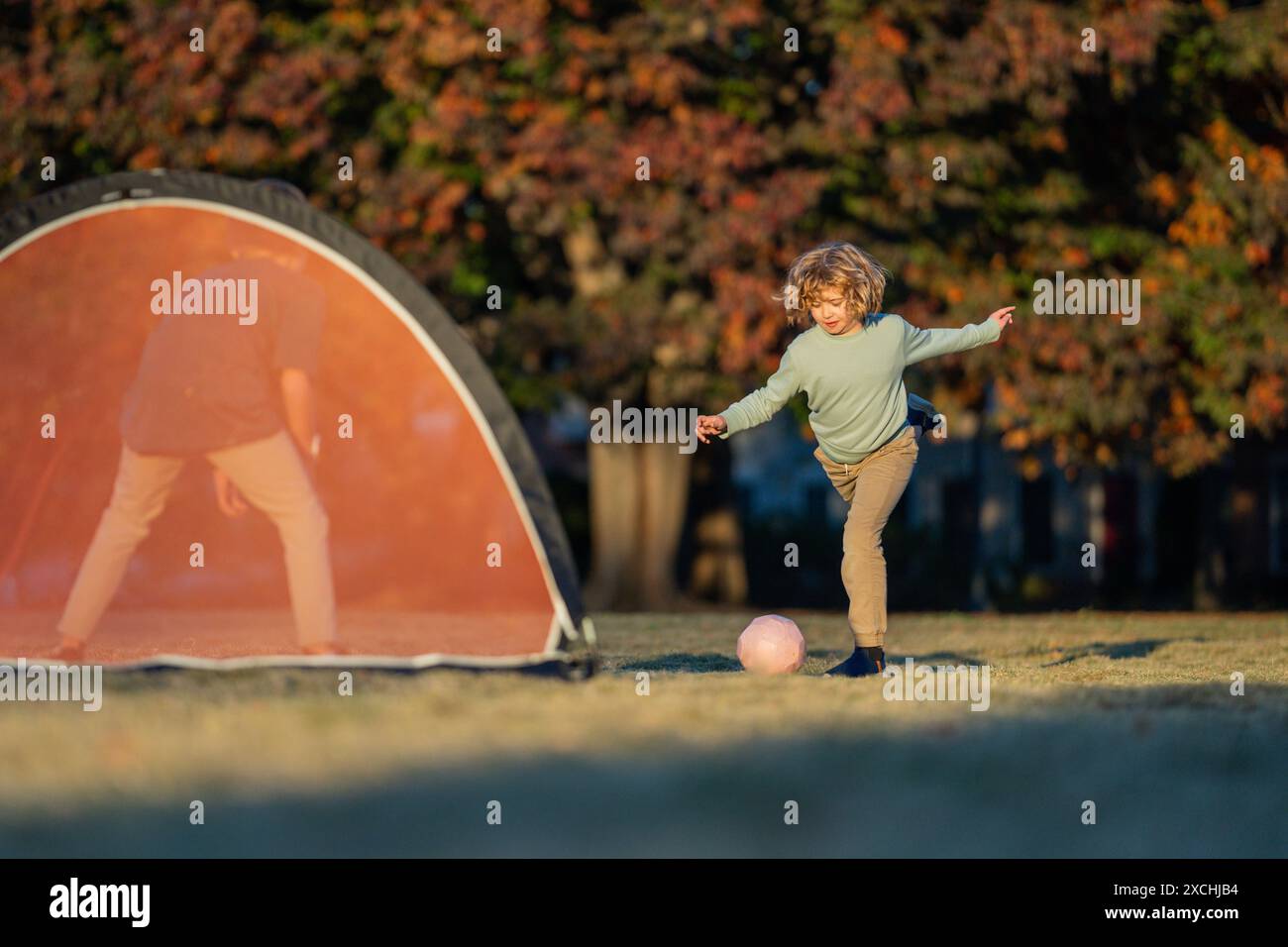 Kid Goalkeeper catches the ball in stadium during a football game ...