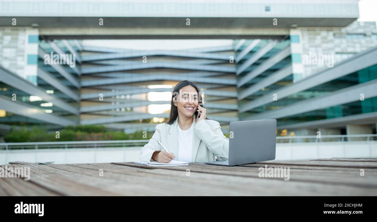 Woman Taking Notes on Phone Call Outside Modern Building, Panorama ...