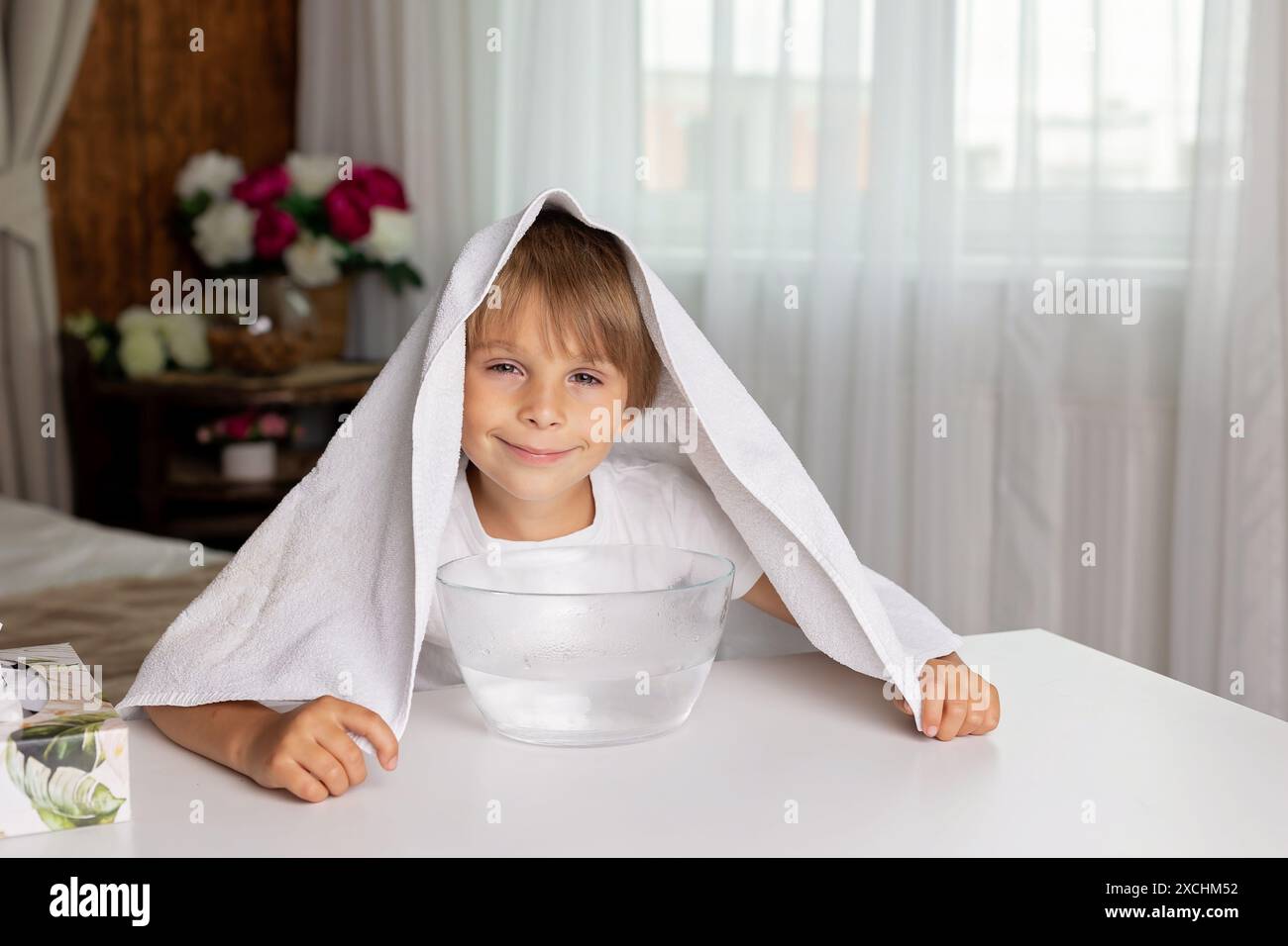 Teenage boy, child, doing steam inhalation at home to soothe and open ...