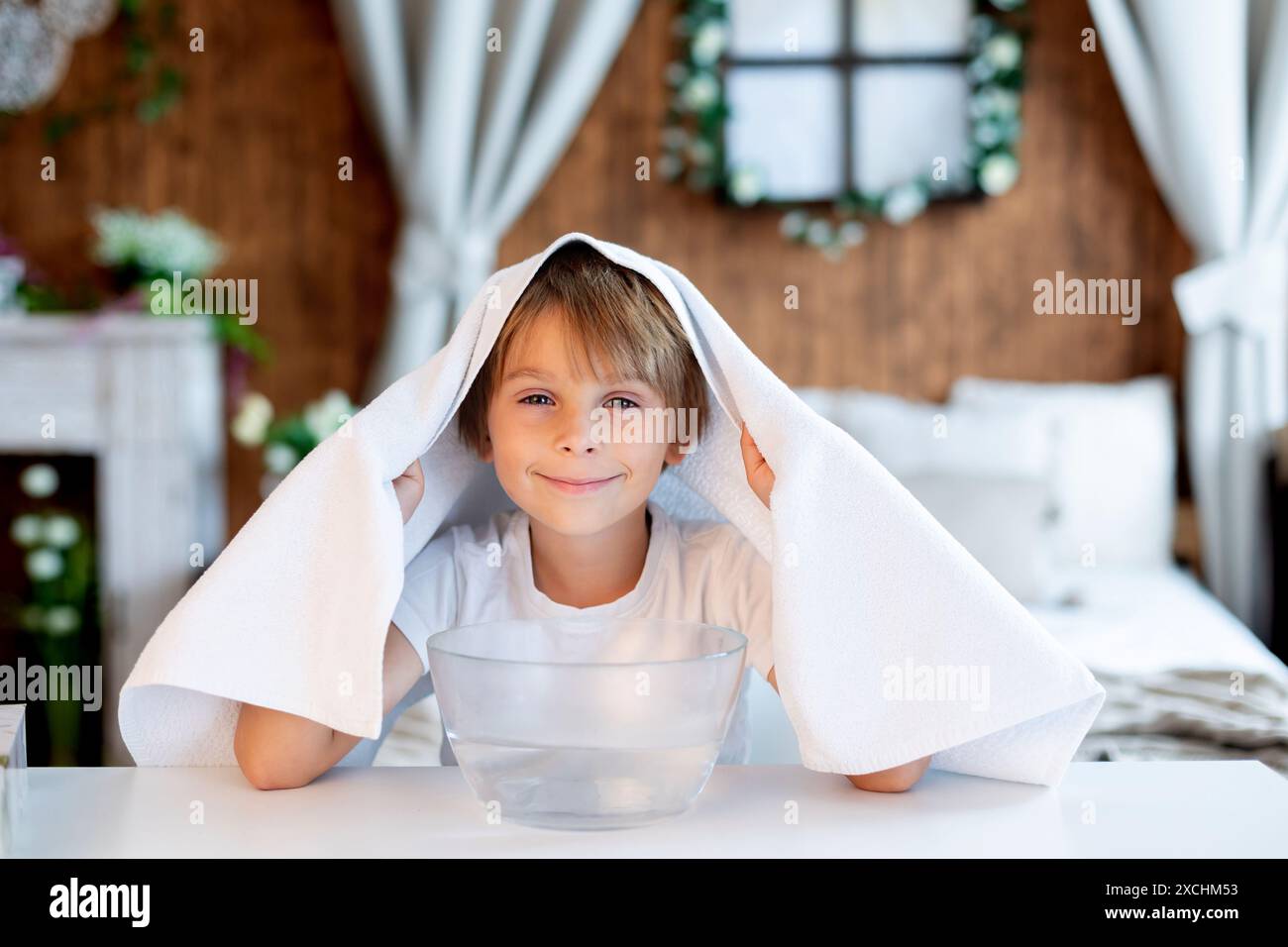 Teenage boy, child, doing steam inhalation at home to soothe and open ...