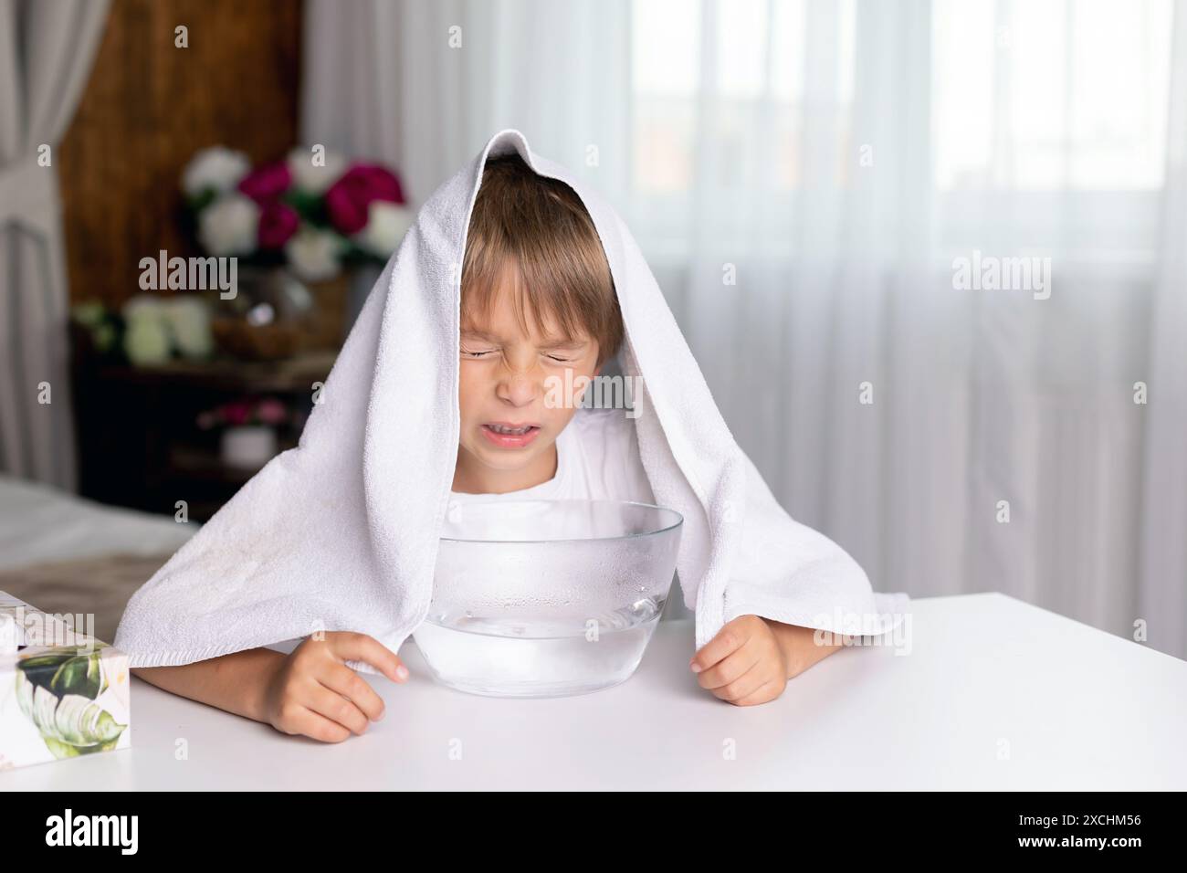 Teenage boy, child, doing steam inhalation at home to soothe and open ...