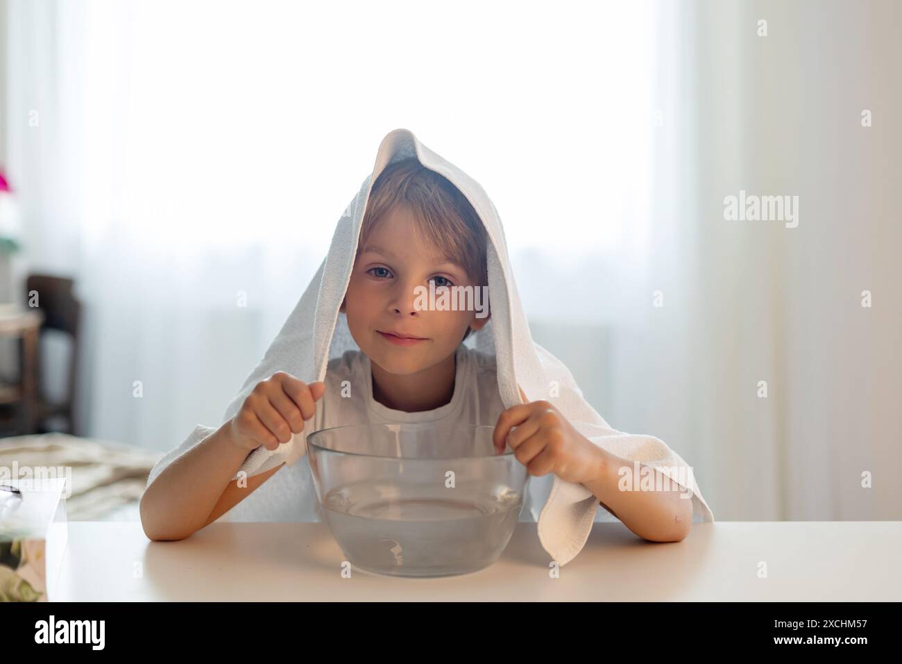 Teenage boy, child, doing steam inhalation at home to soothe and open ...
