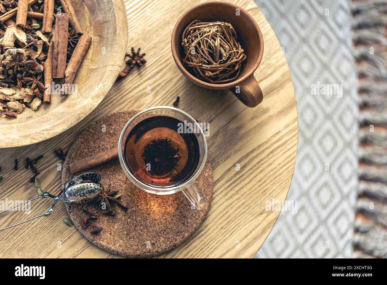 Cup of freshly brewed black tea, different types of spices on wooden ...