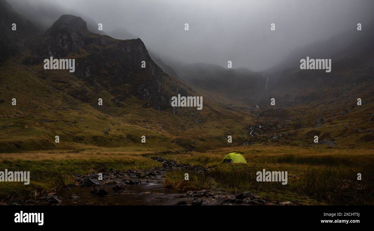 Wide view of a green camping tent next to a river in Corrie Fee ...