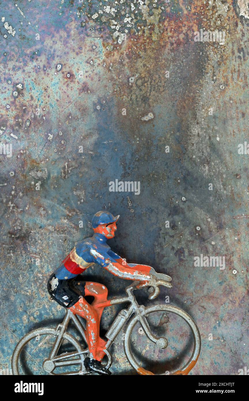 Vintage lead model of cyclist on racing bike powering up an incline ...