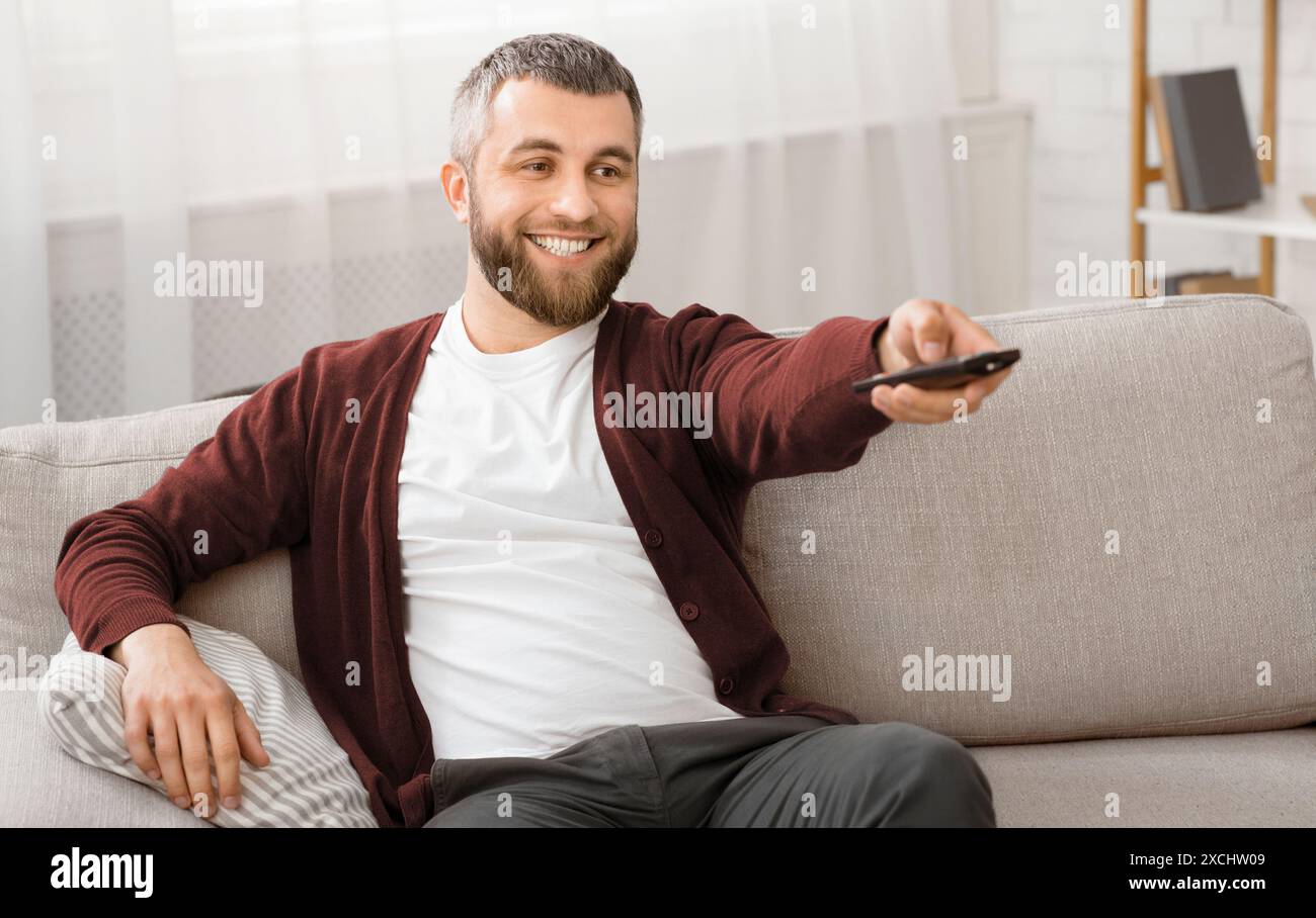 Man Sitting on Couch Holding Remote Control Stock Photo - Alamy