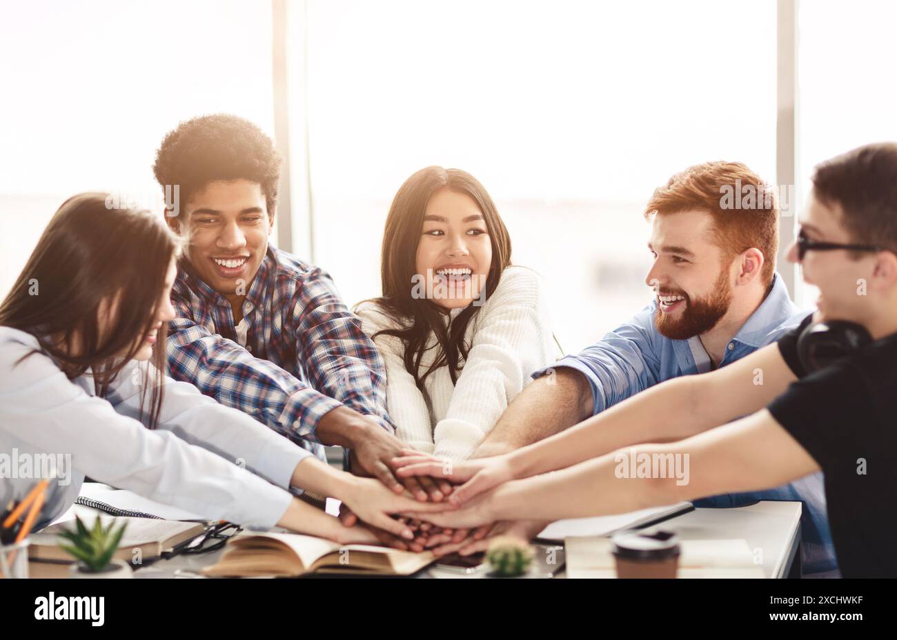 All together! Happy students putting their hands together Stock Photo ...